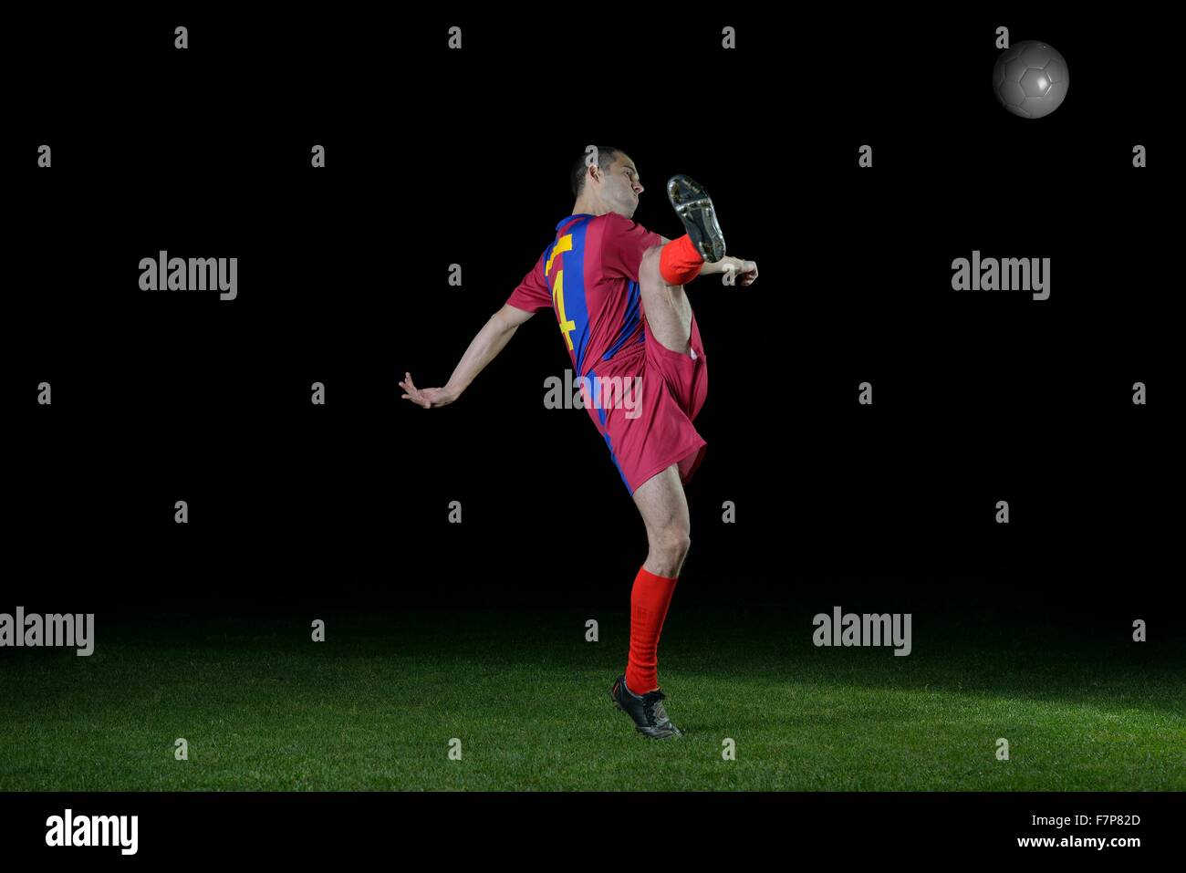 soccer player doing kick with ball on football stadium field isolated on black background Stock ...