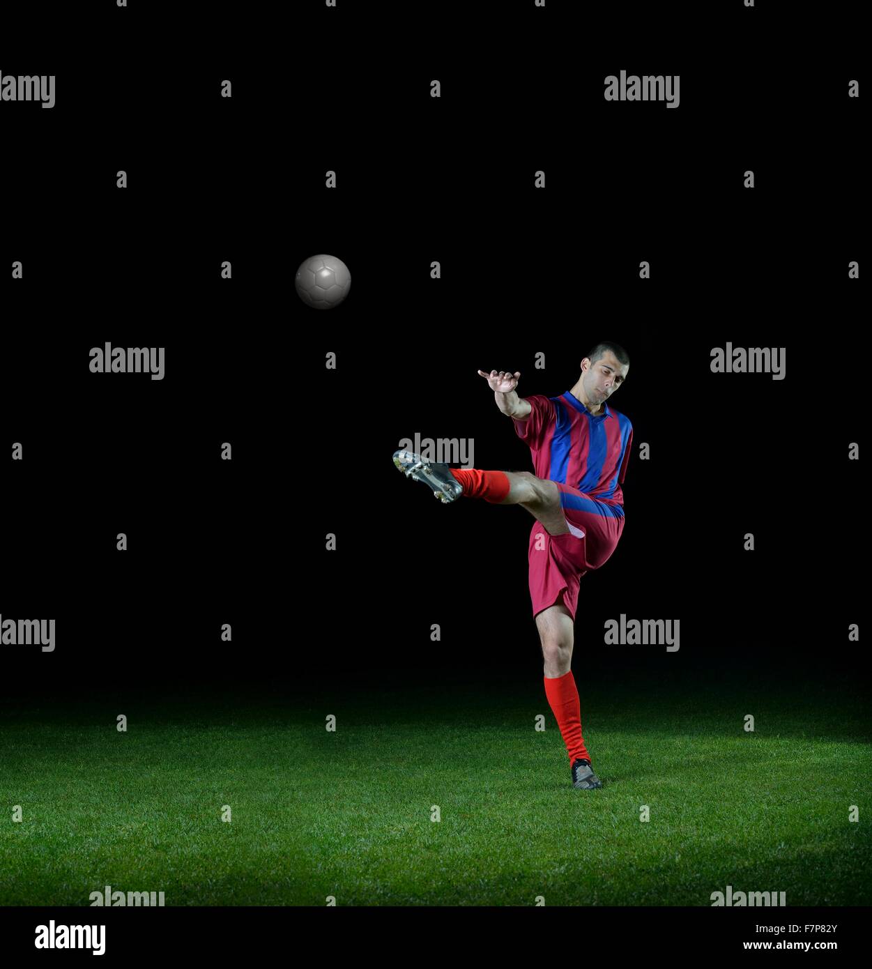 soccer player doing kick with ball on football stadium field isolated ...