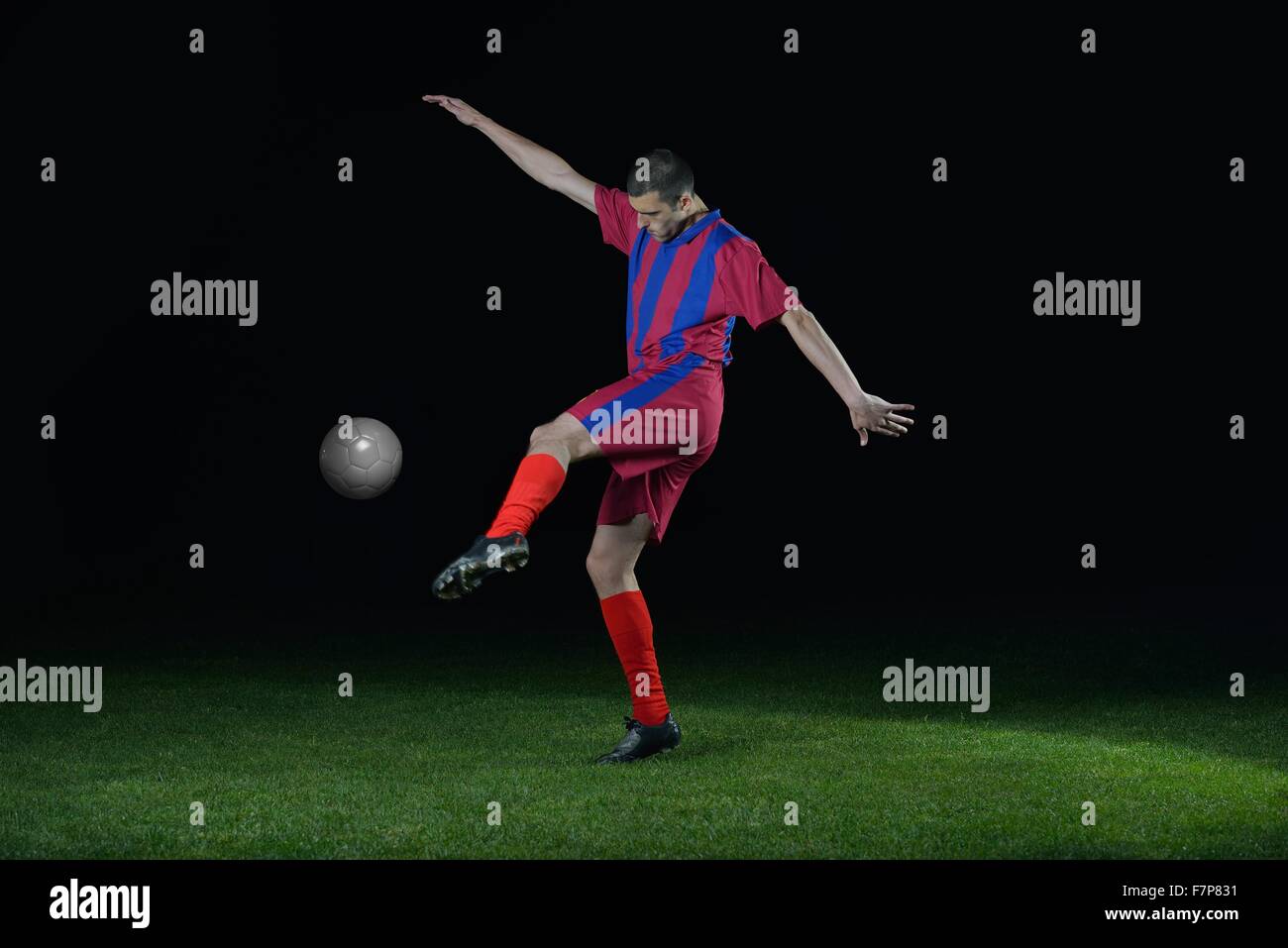 soccer player doing kick with ball on football stadium field isolated ...