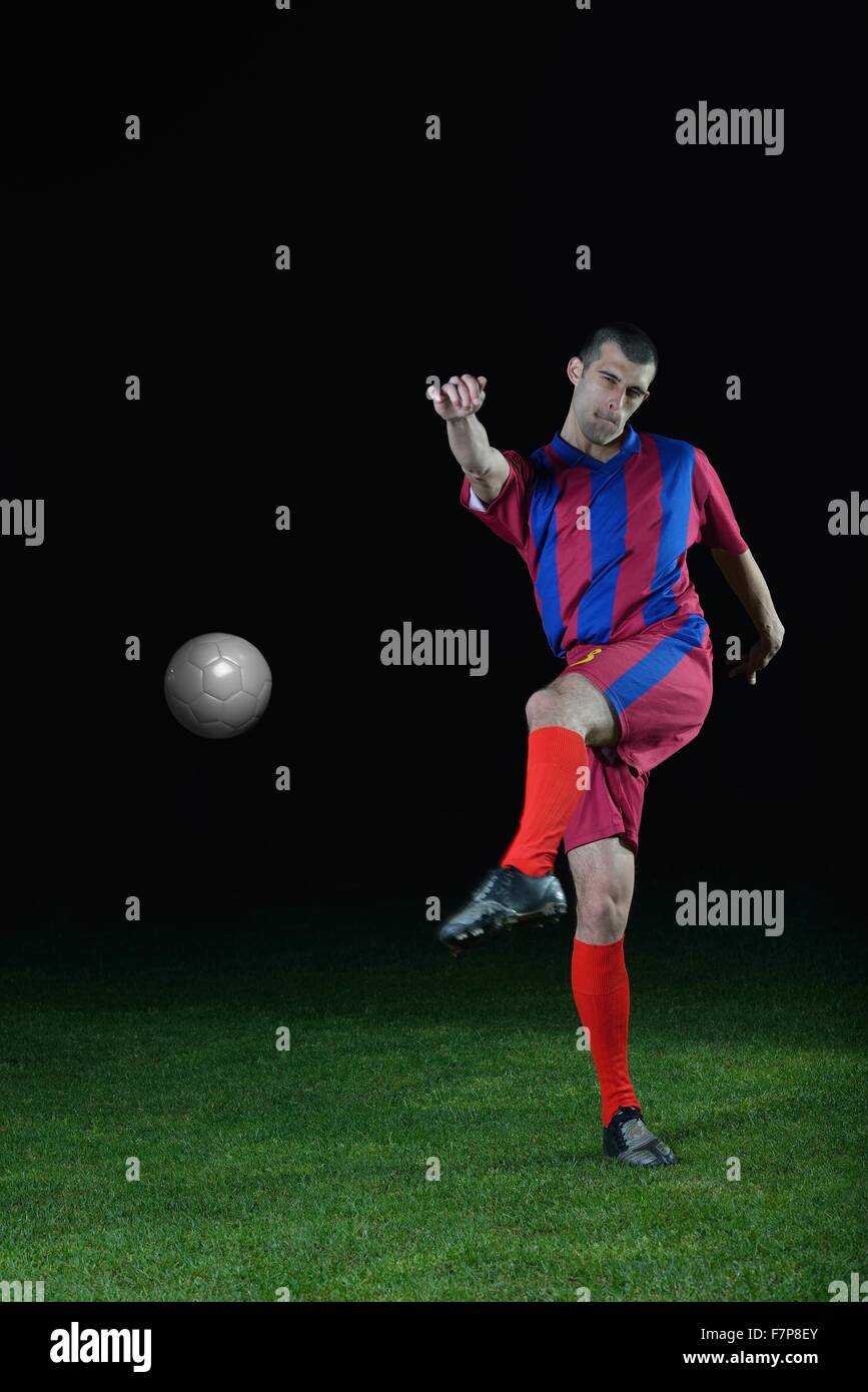 soccer player doing kick with ball on football stadium field isolated ...