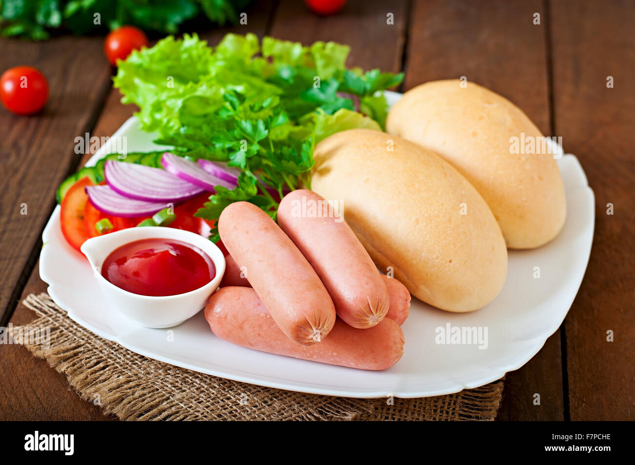 Ingredients for the preparation of hot dogs on a white plate. Top view ...