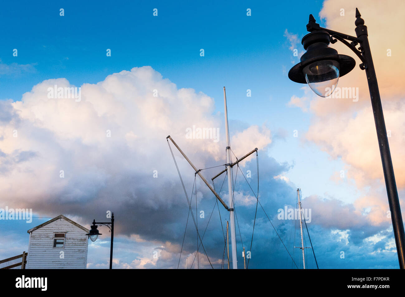 A lamp post and dinghy masts in the cloudy, winter Norfolk Marina ...