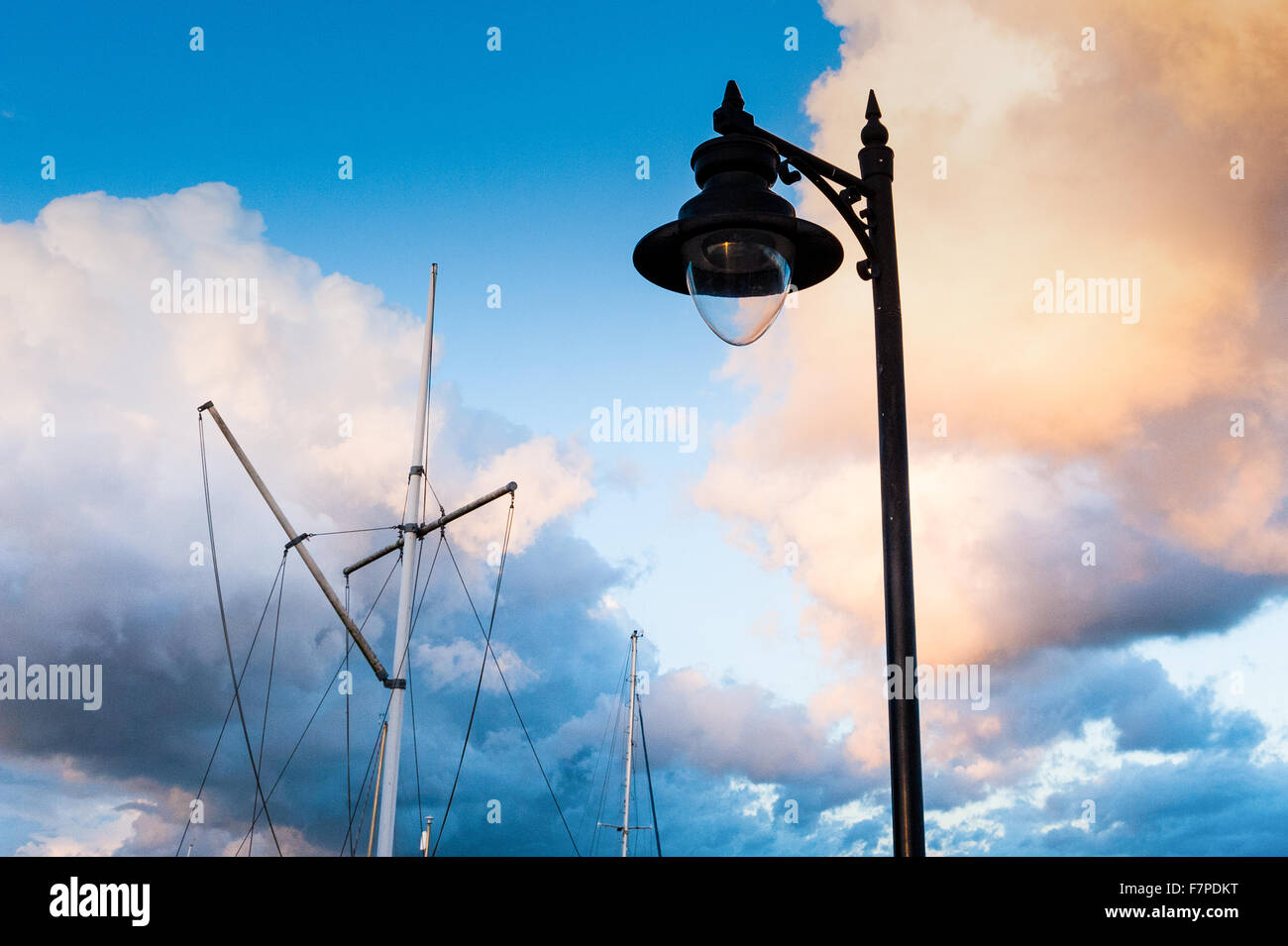 A lamp post and dinghy masts in the cloudy, winter Norfolk Marina ...