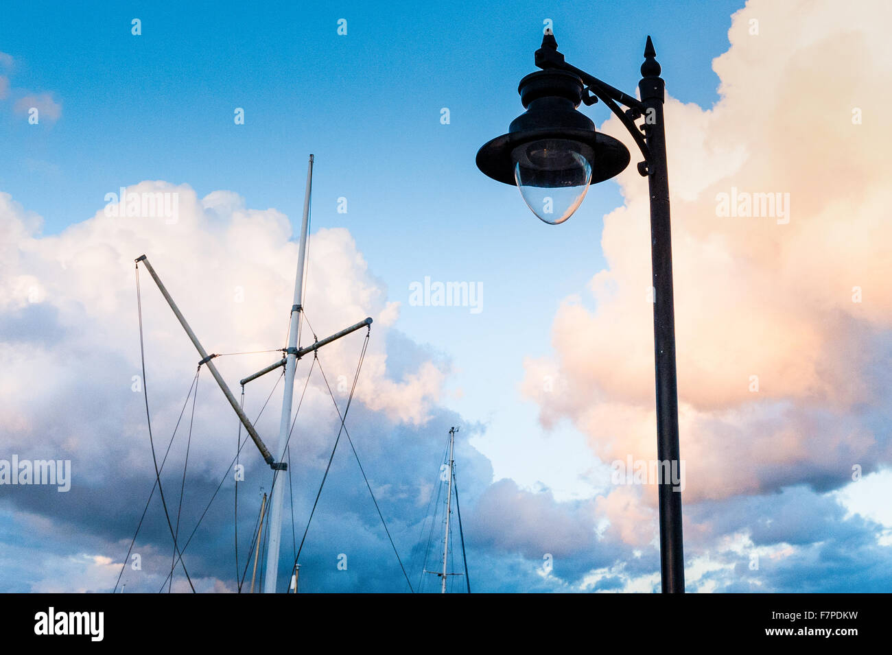 A lamp post and dinghy masts in the cloudy, winter Norfolk Marina ...