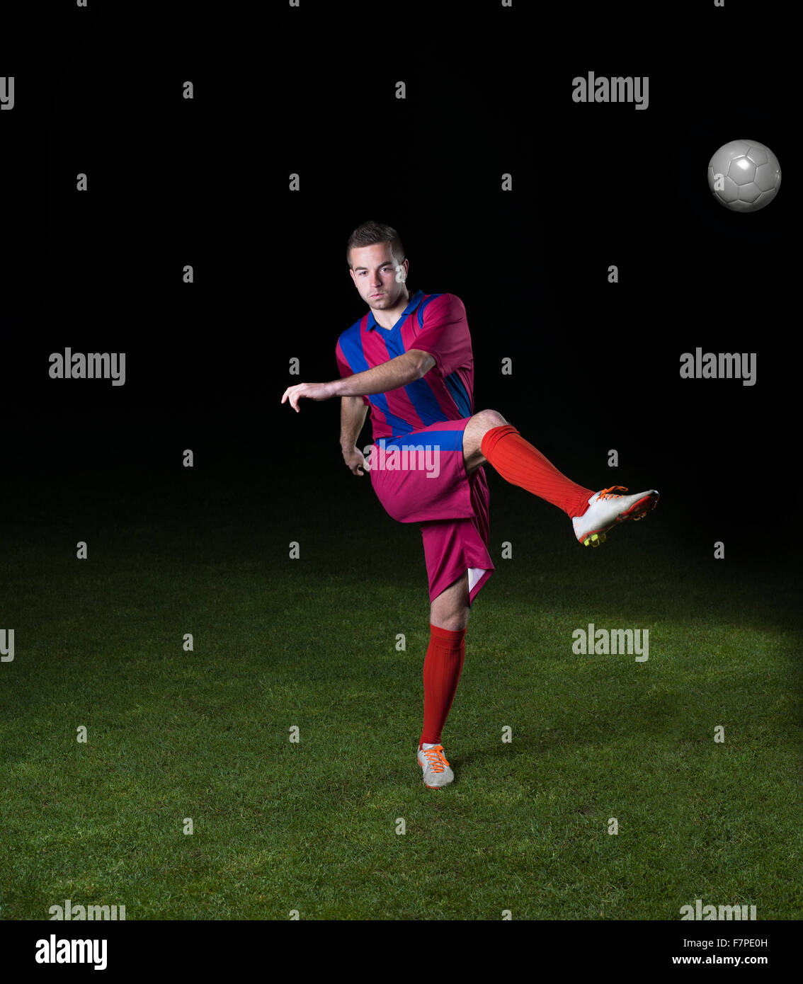 soccer player doing kick with ball on football stadium field isolated ...