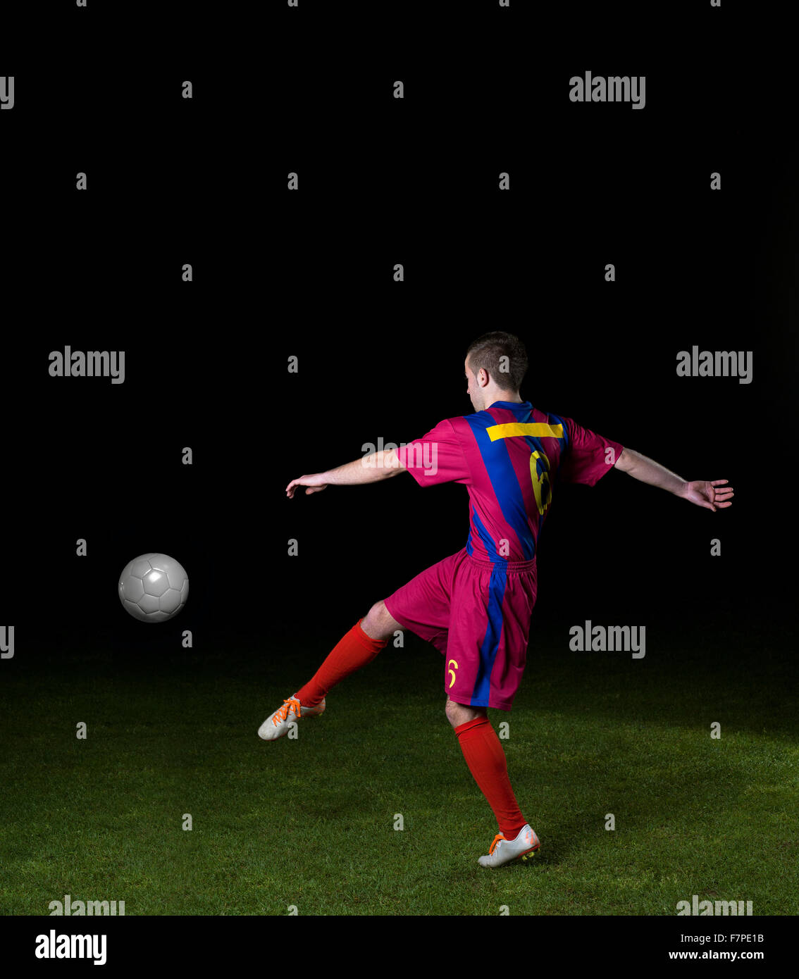 soccer player doing kick with ball on football stadium field isolated ...