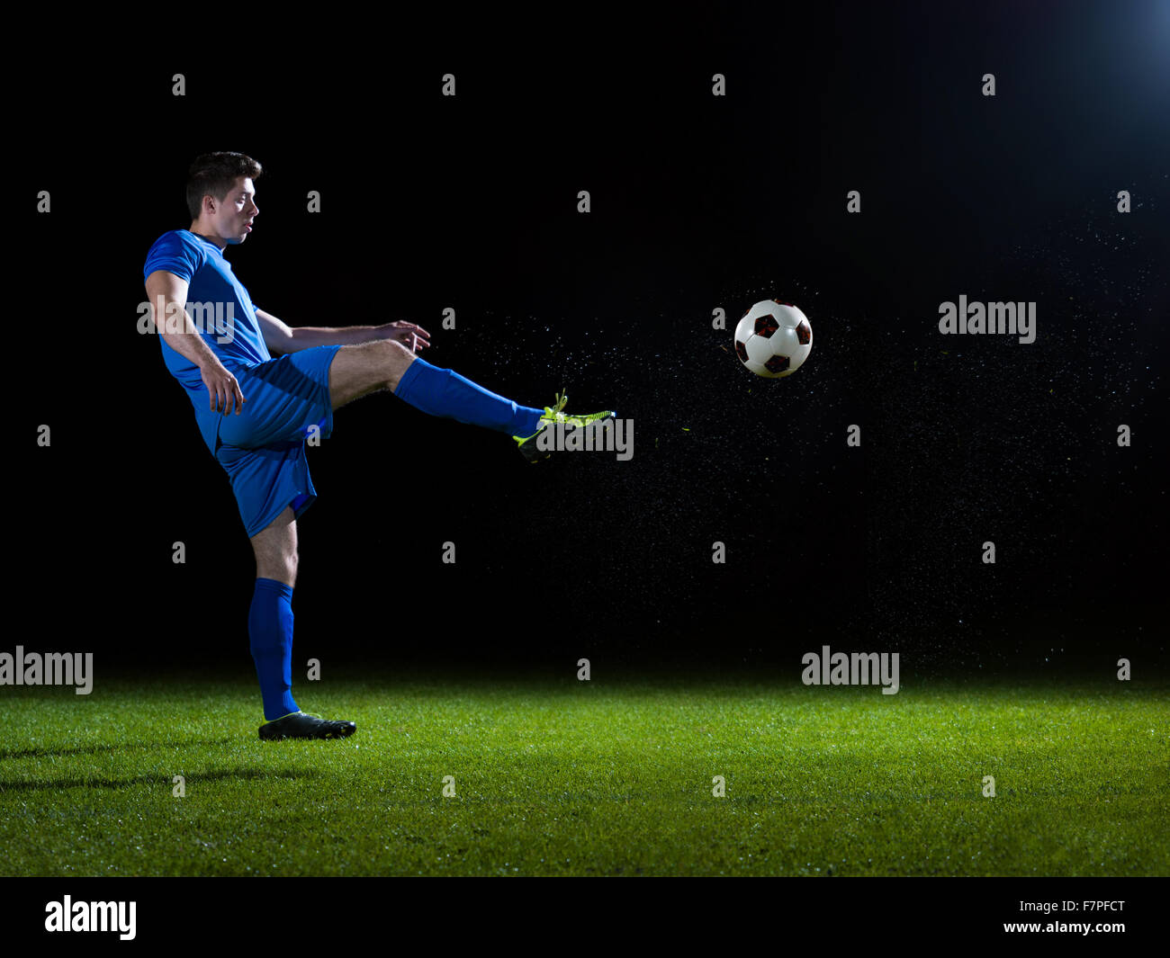 soccer player doing kick with ball on football stadium field isolated ...
