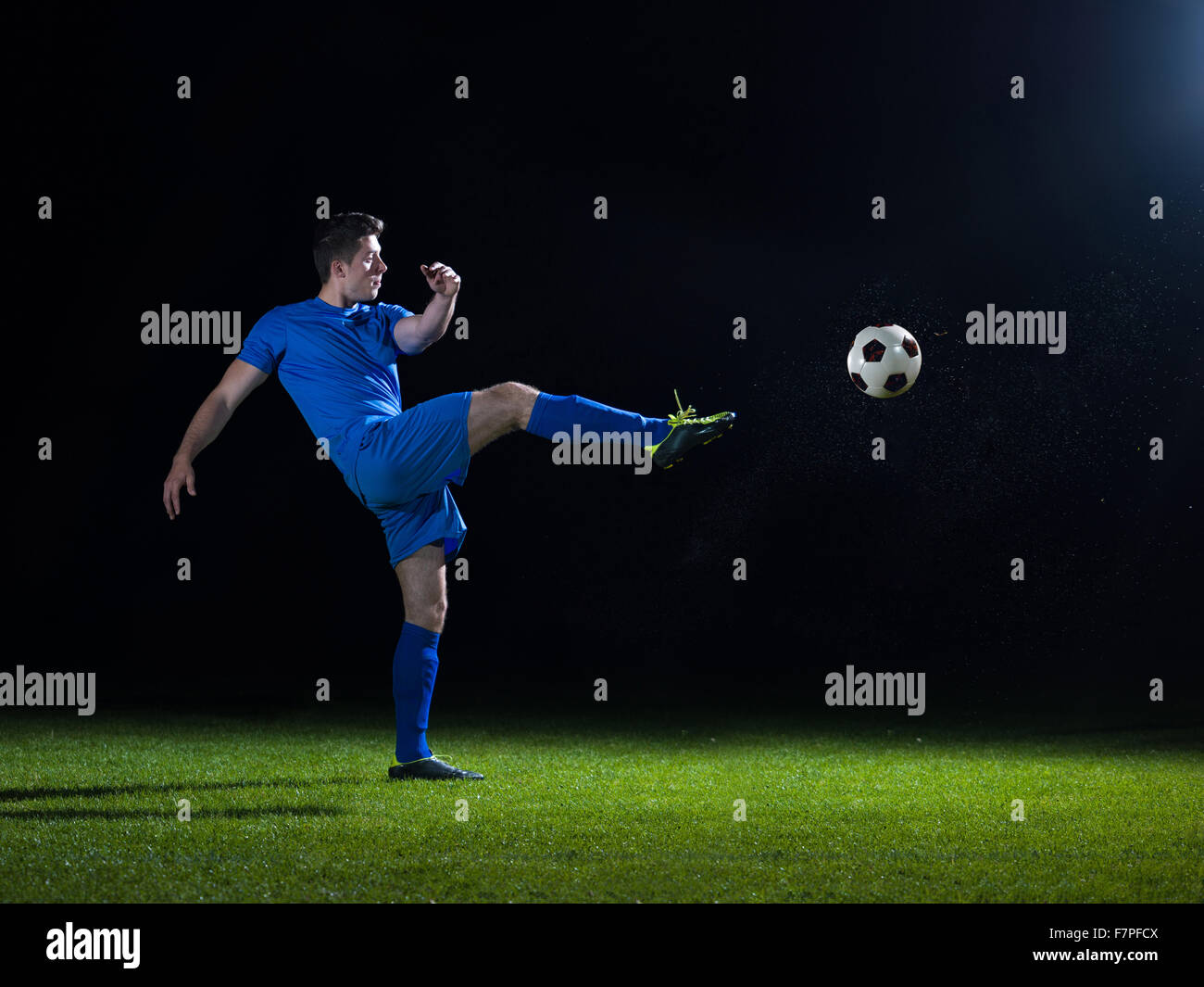 soccer player doing kick with ball on football stadium field isolated ...