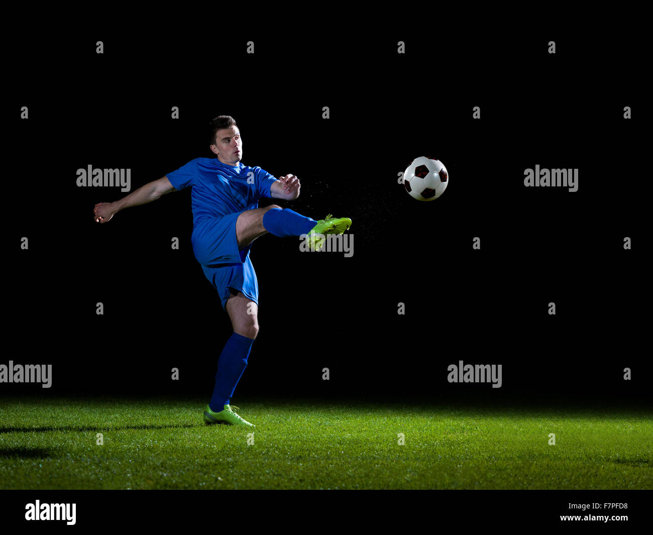 soccer player doing kick with ball on football stadium field isolated ...