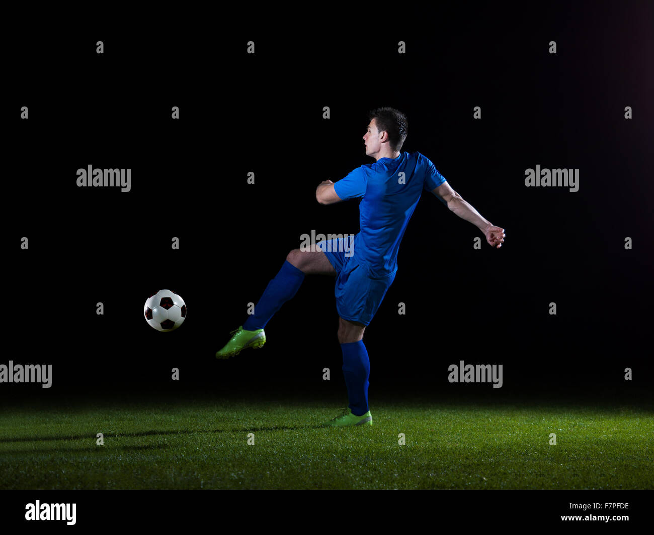 soccer player doing kick with ball on football stadium field isolated ...