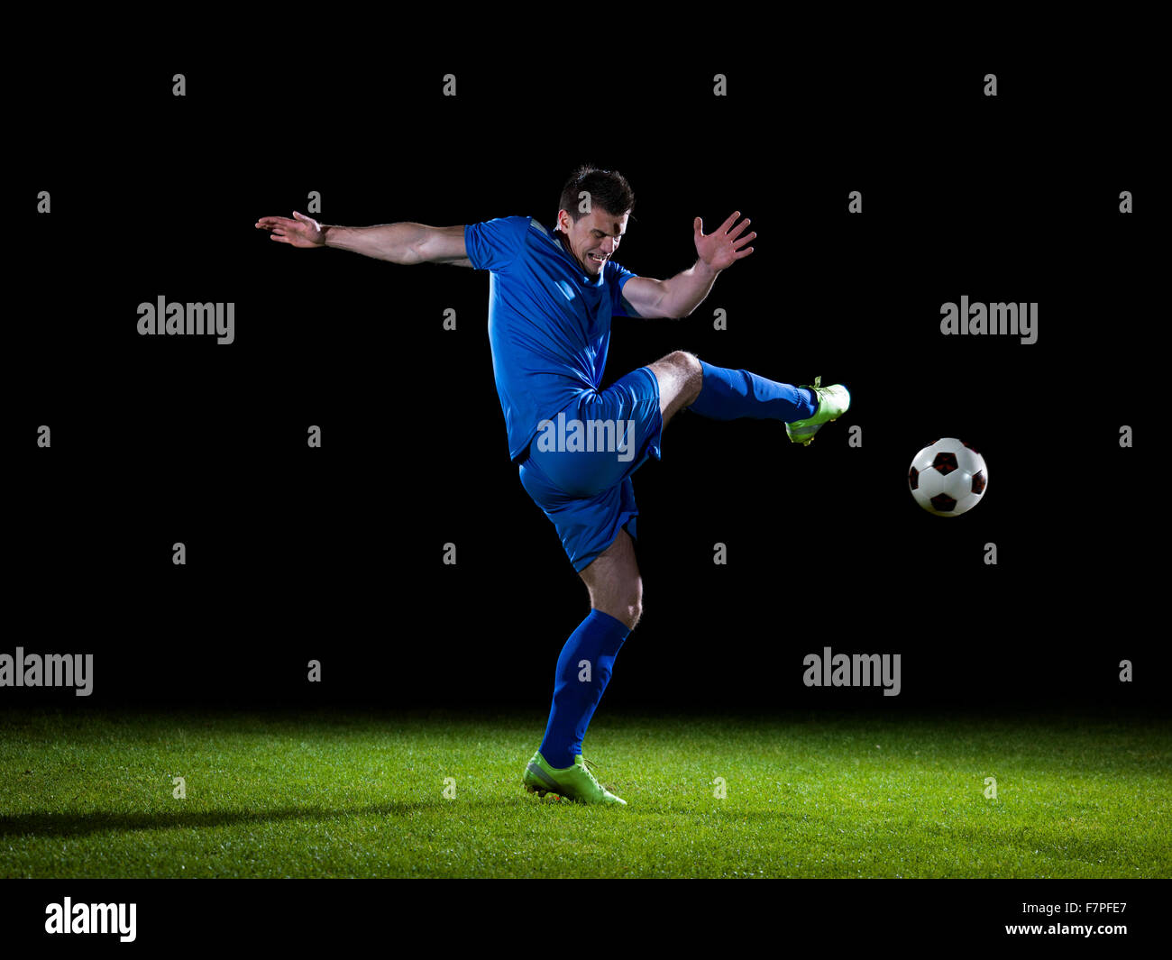 soccer player doing kick with ball on football stadium field isolated ...
