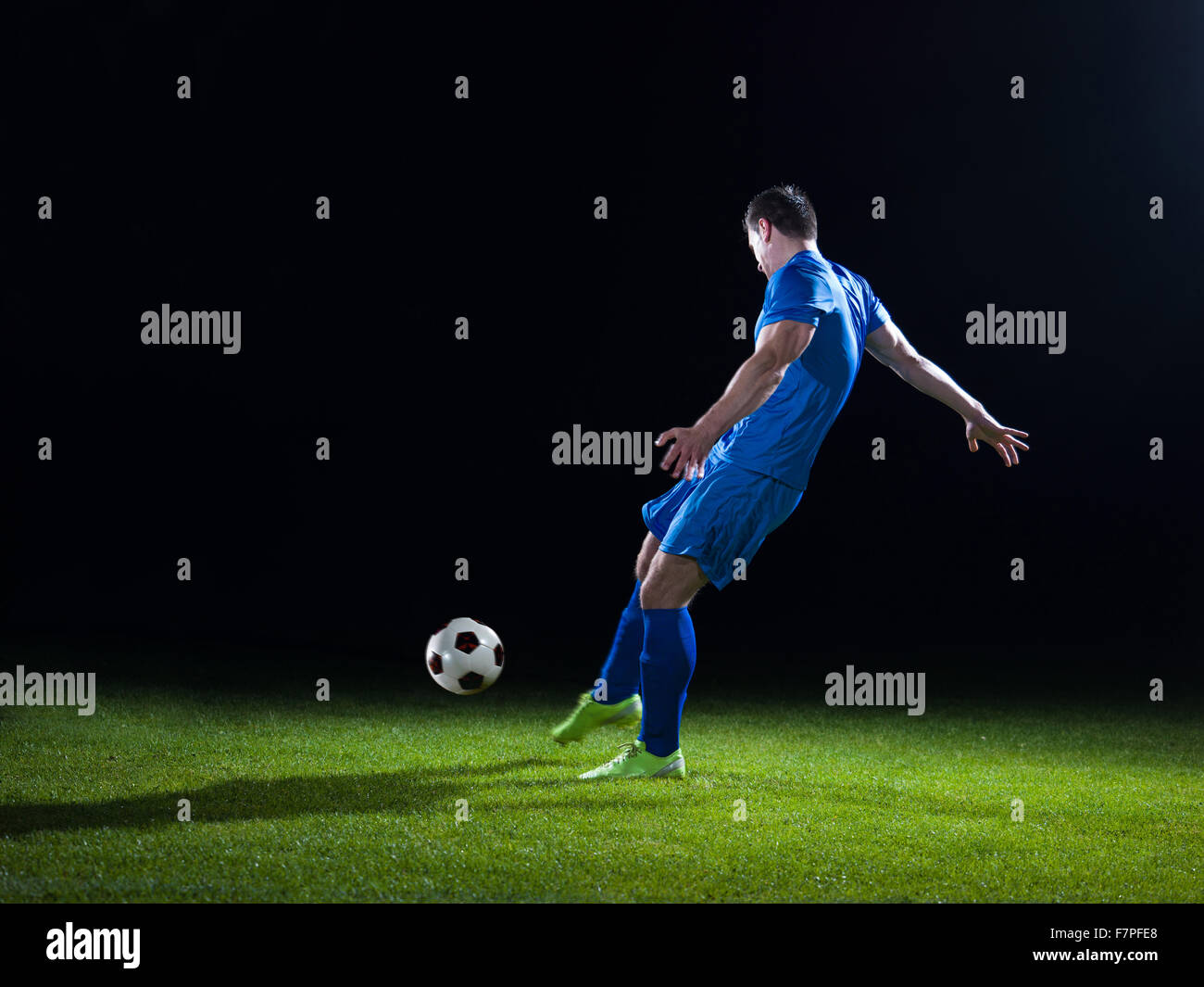 soccer player doing kick with ball on football stadium field isolated ...