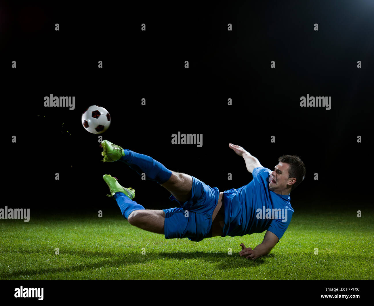 soccer player doing kick with ball on football stadium field isolated ...