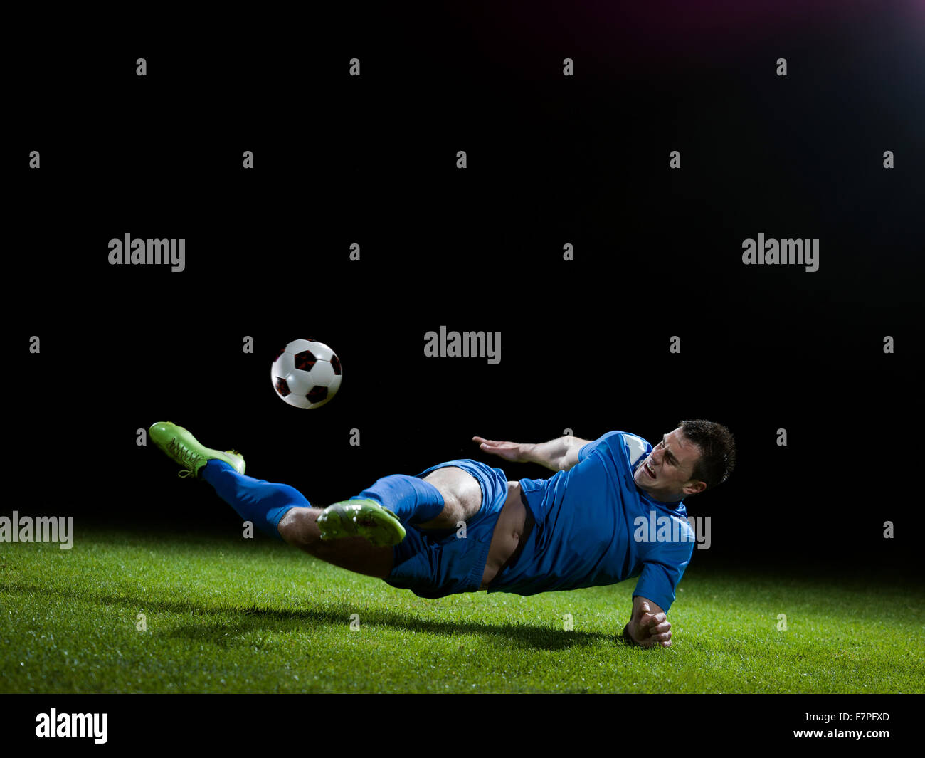 soccer player doing kick with ball on football stadium field isolated ...