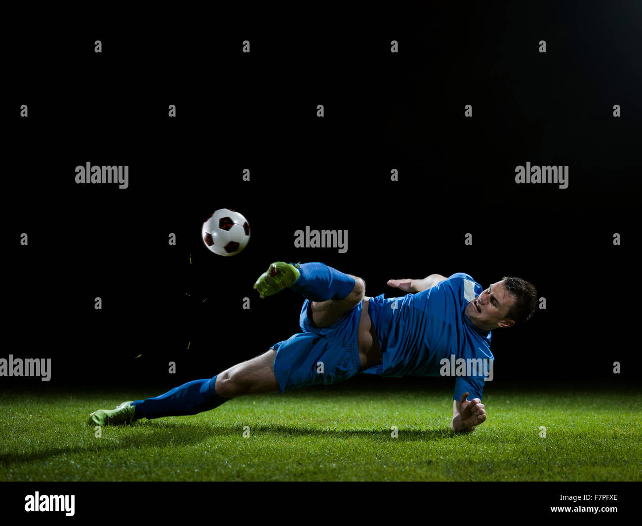 soccer player doing kick with ball on football stadium field isolated ...