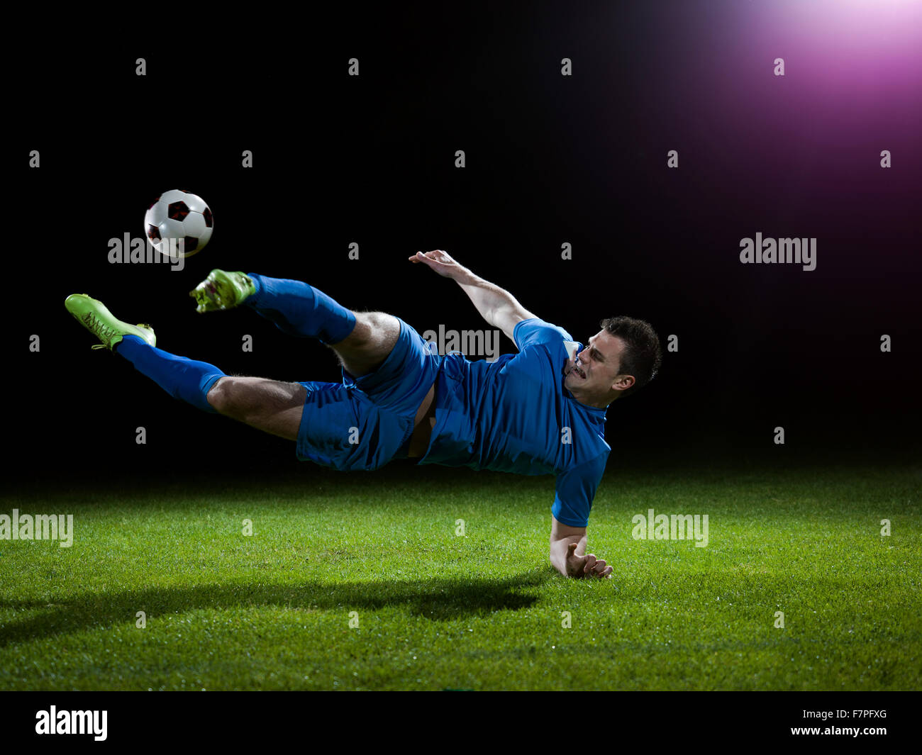 soccer player doing kick with ball on football stadium field isolated ...