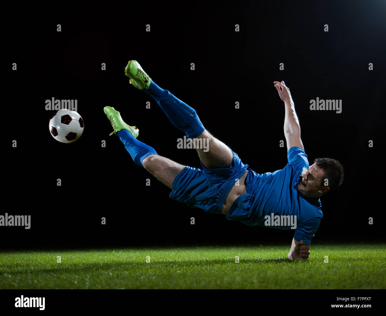 soccer player doing kick with ball on football stadium field isolated ...
