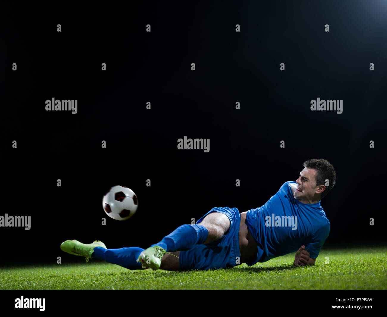 soccer player doing kick with ball on football stadium field isolated on black background Stock ...
