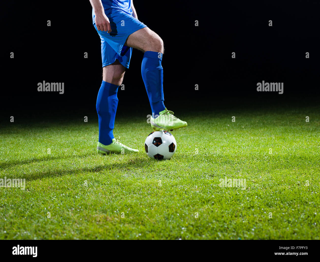 soccer player doing kick with ball on football stadium field isolated ...