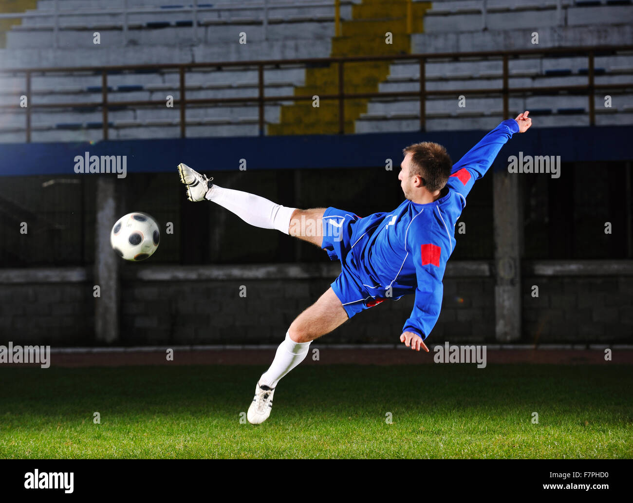soccer player doing kick with ball on football stadium field isolated ...