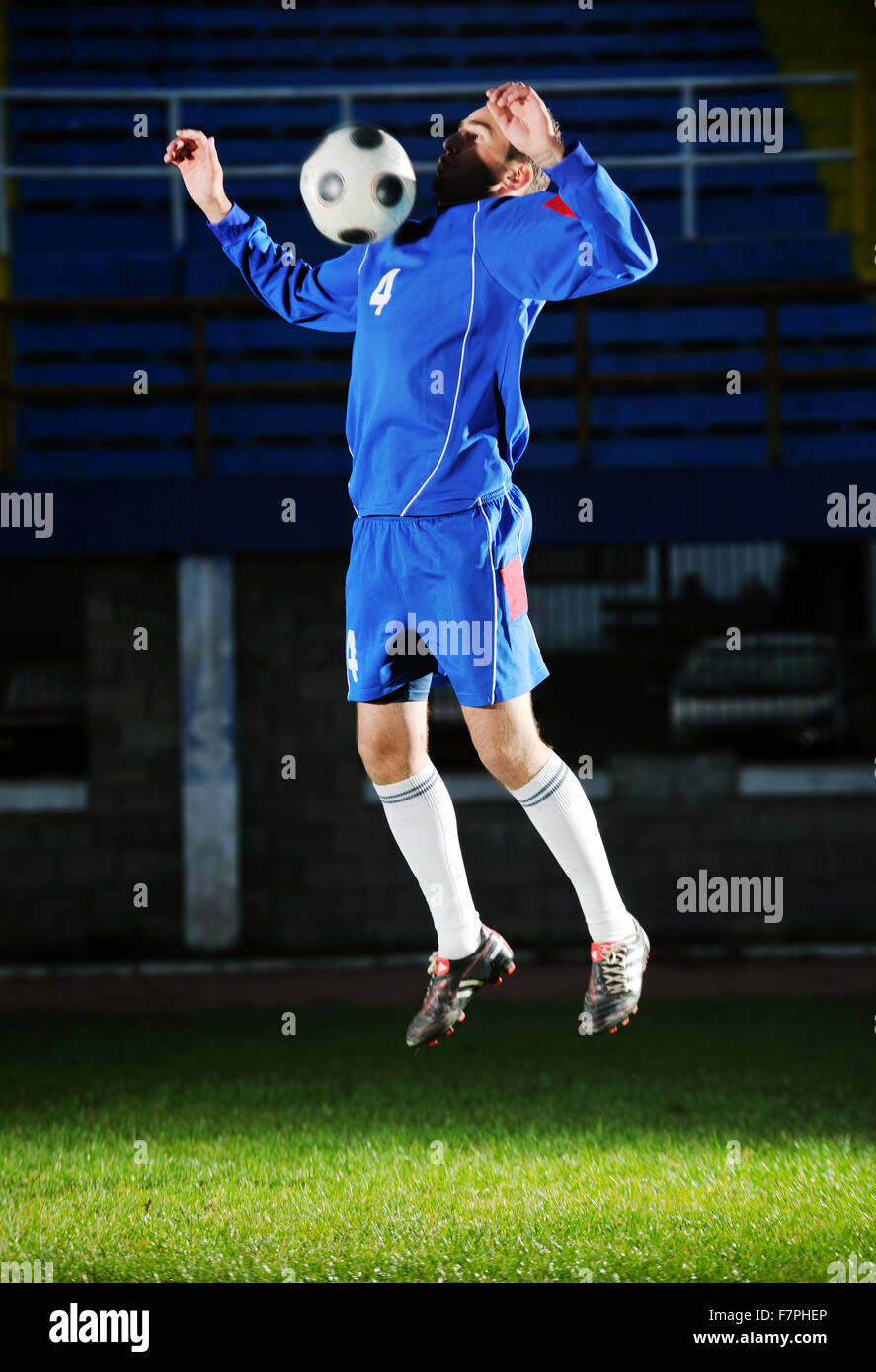 soccer player doing kick with ball on football stadium field isolated on black background in ...