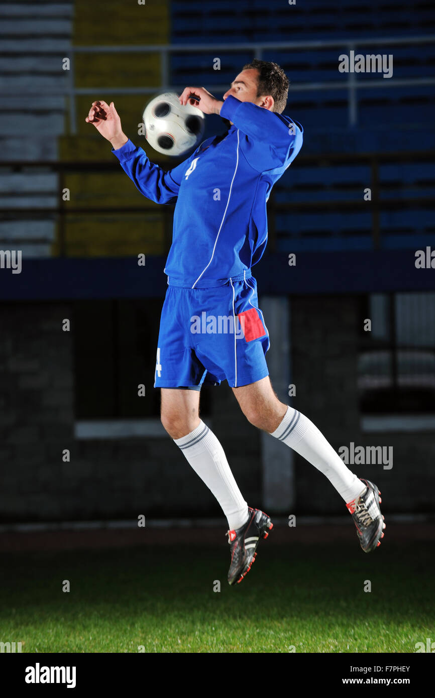 soccer player doing kick with ball on football stadium field isolated on black background in ...