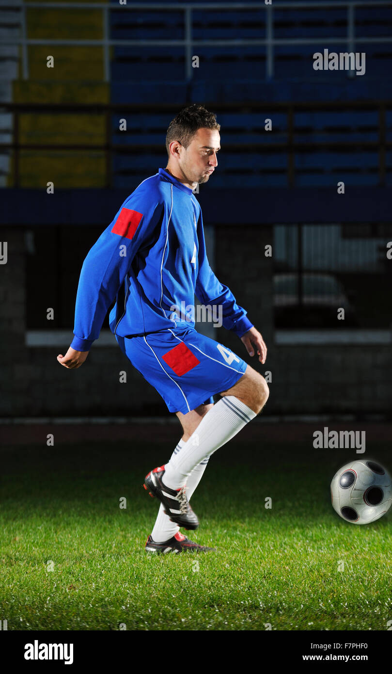 soccer player doing kick with ball on football stadium field isolated ...
