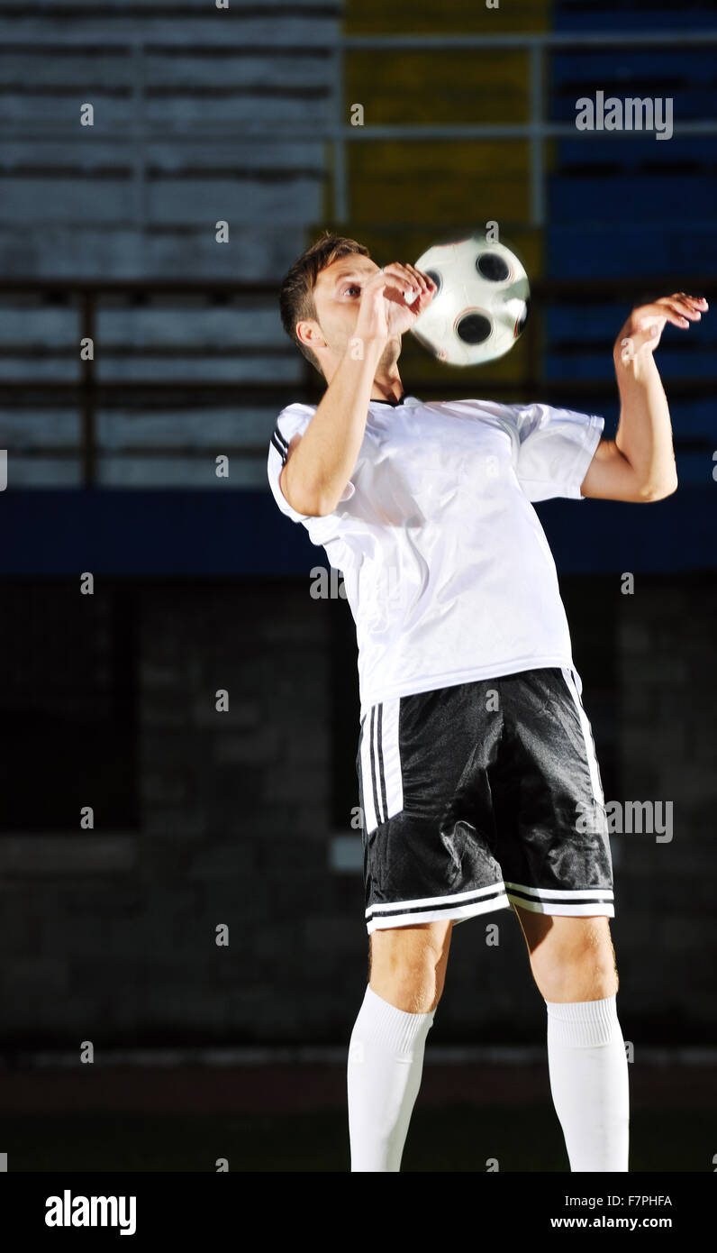 soccer player doing kick with ball on football stadium field isolated on black background in ...