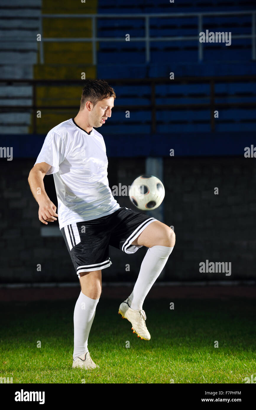 soccer player doing kick with ball on football stadium field isolated on black background in ...