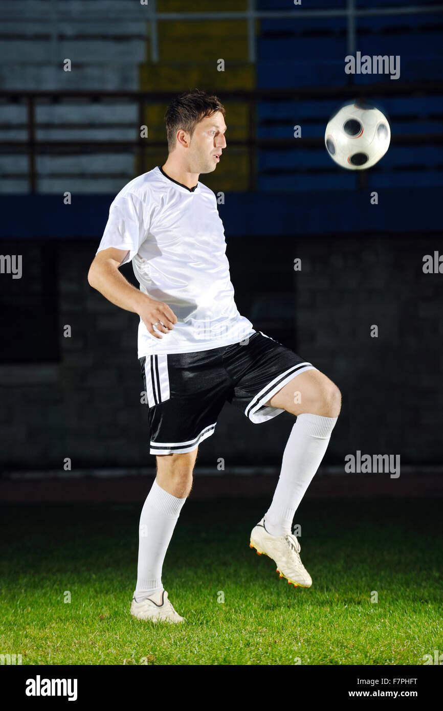 soccer player doing kick with ball on football stadium field isolated ...