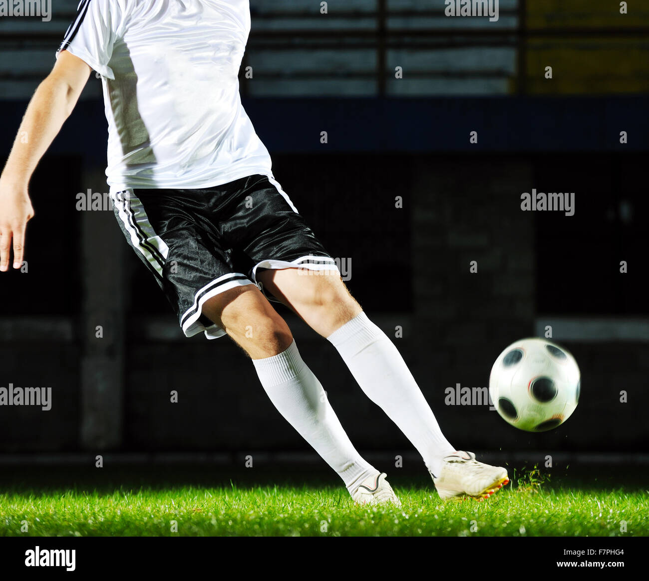 soccer player doing kick with ball on football stadium field isolated ...