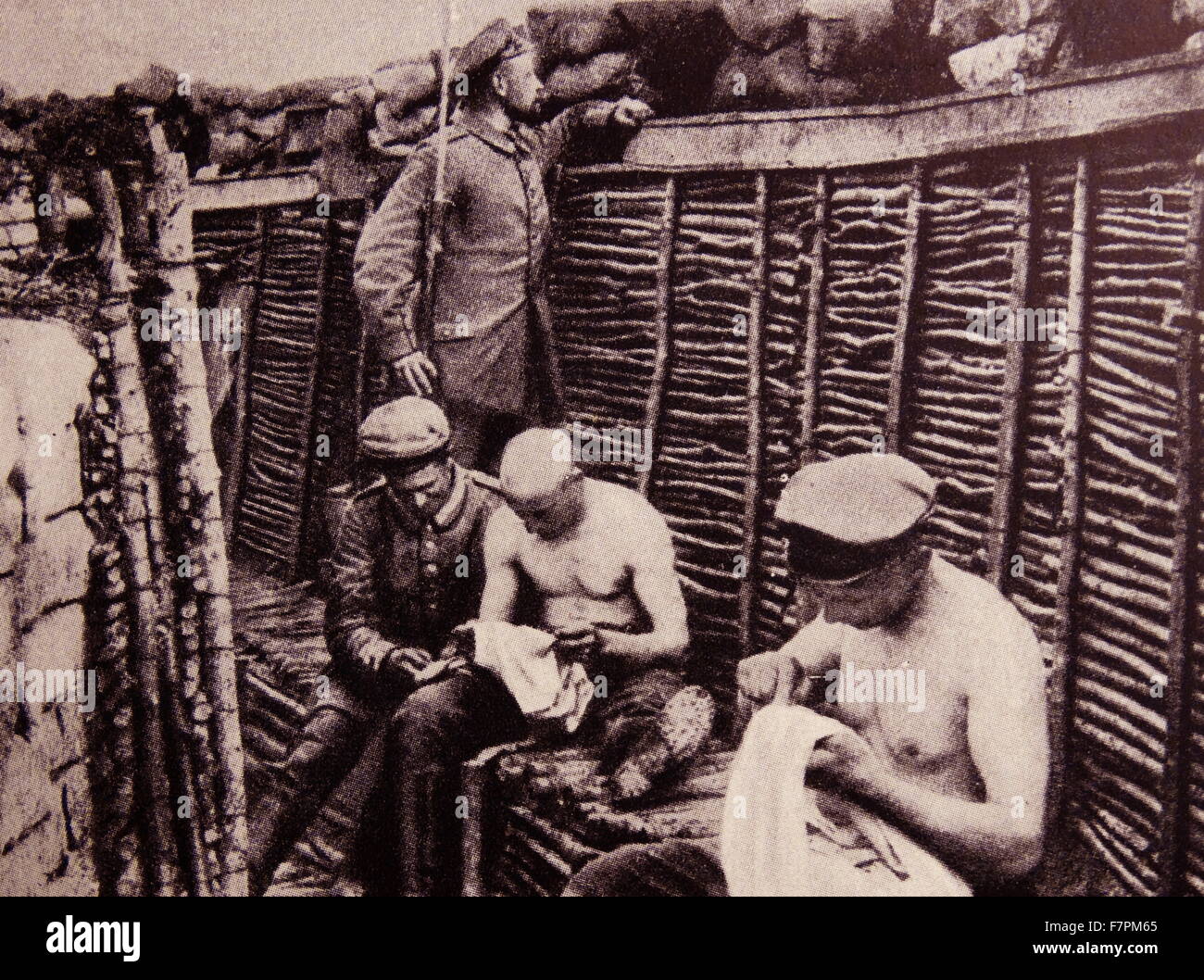Photograph of soldiers hunting for lice on their clothing in the ...