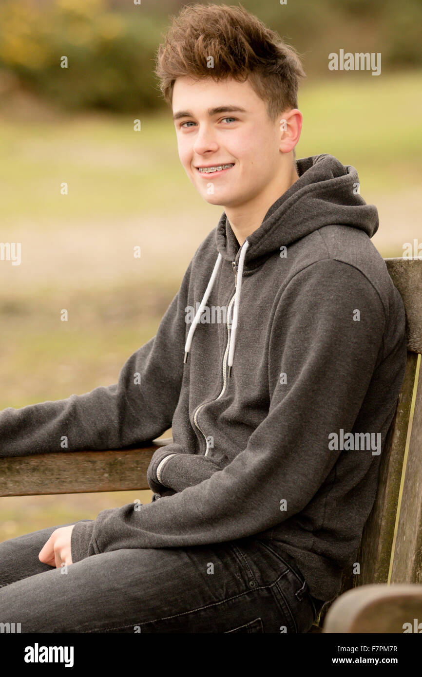Boy sitting on wooden bench hi-res stock photography and images - Alamy