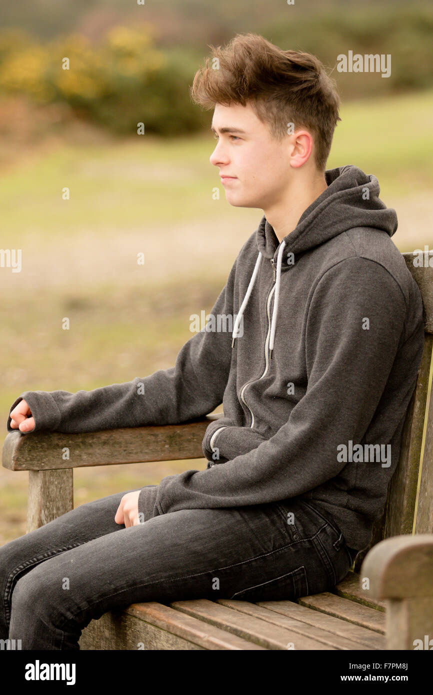 Boy sitting on wooden bench hi-res stock photography and images - Alamy