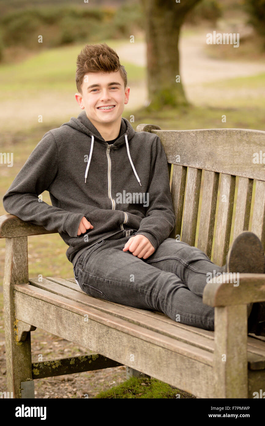 Boy sitting on wooden bench hi-res stock photography and images - Alamy