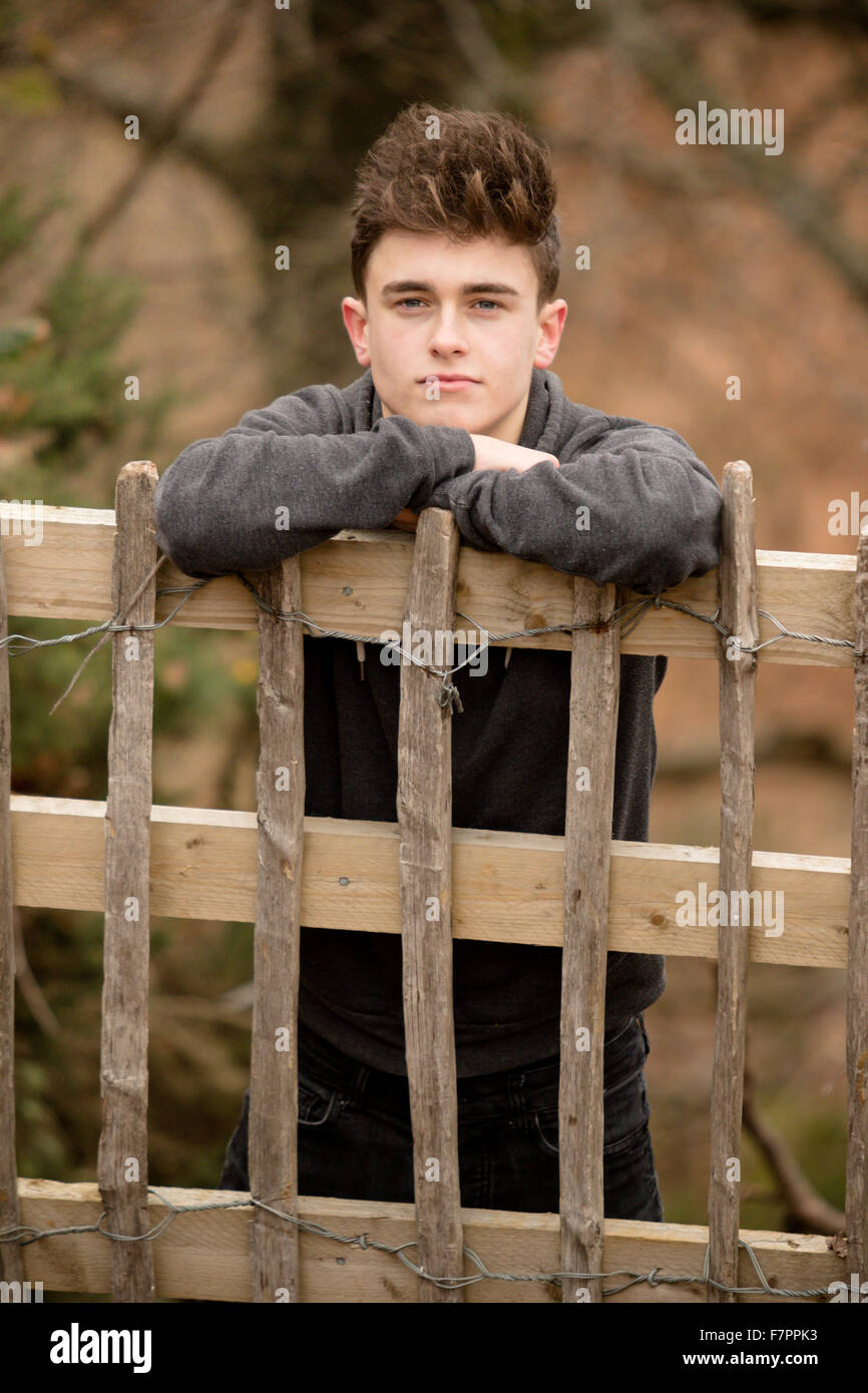 Boy leaning on fence hi-res stock photography and images - Alamy