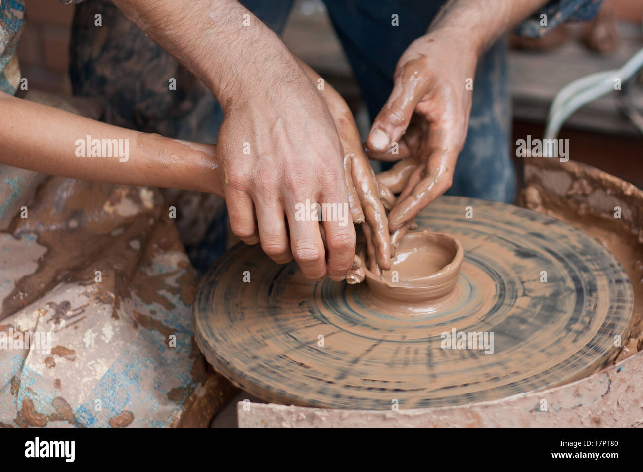 Potter teaches to sculpt in clay pot on the turning pottery wheel Stock ...