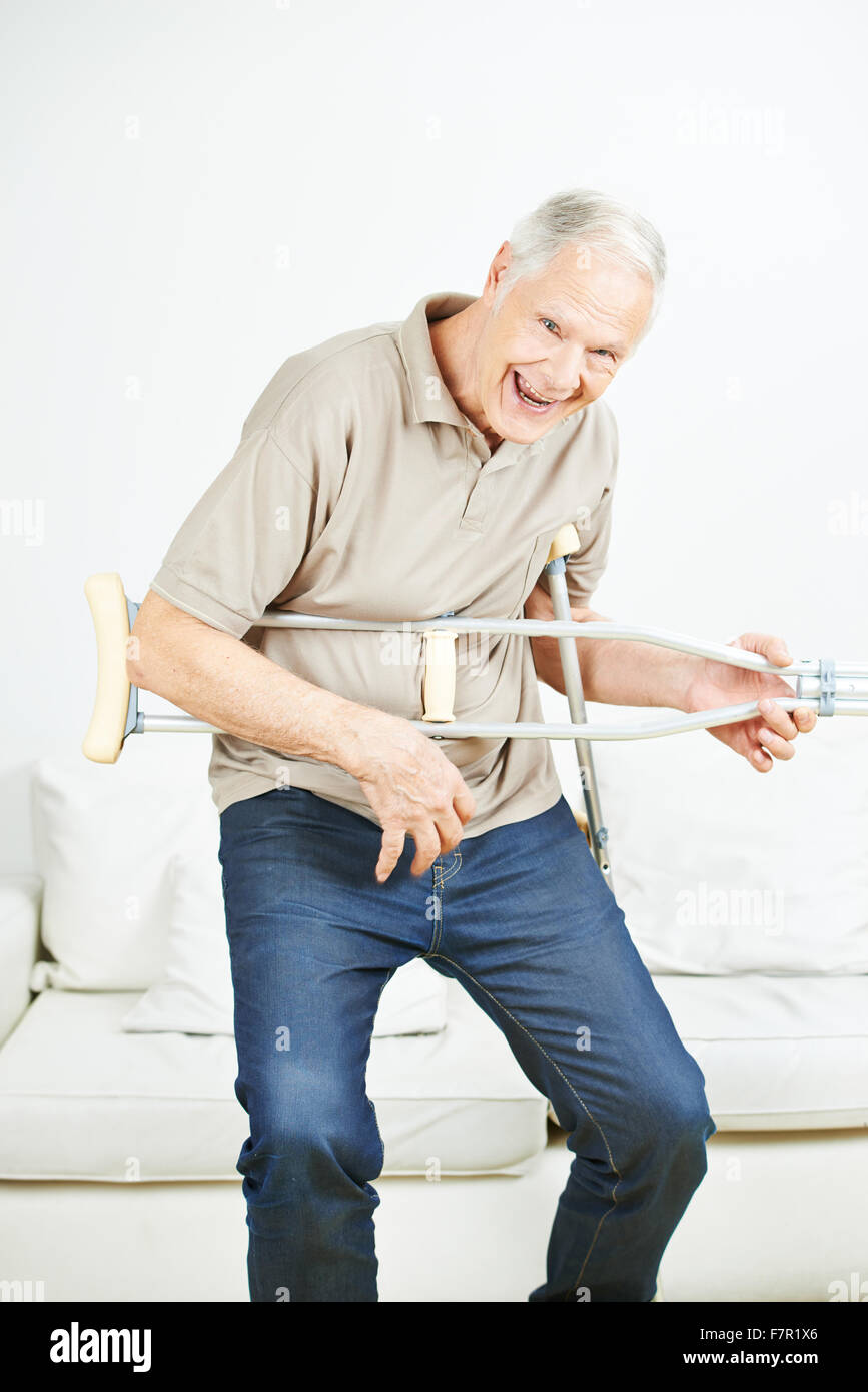 Happy senior man rocking with air guitar crutches Stock Photo - Alamy