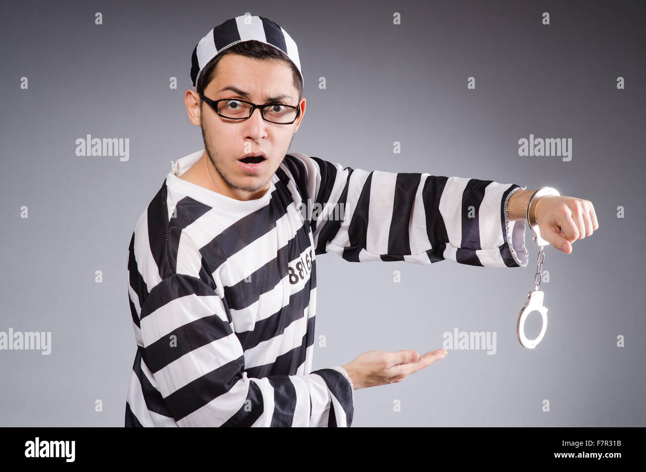 Funny prisoner in handcuffs isolated on gray Stock Photo - Alamy