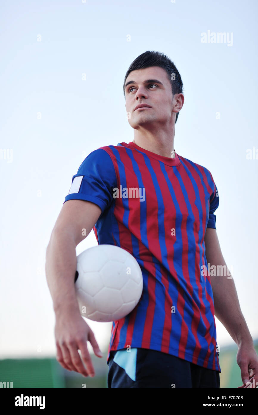 portrait of young handsome soccer player man at football stadium and ...
