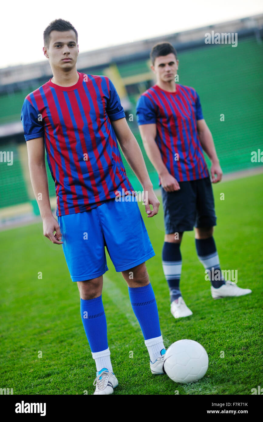 portrait of young handsome soccer player man at football stadium and ...