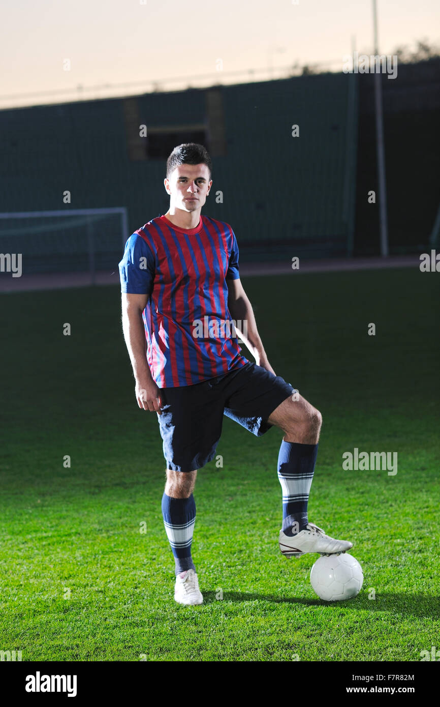 portrait of young handsome soccer player man at football stadium and ...