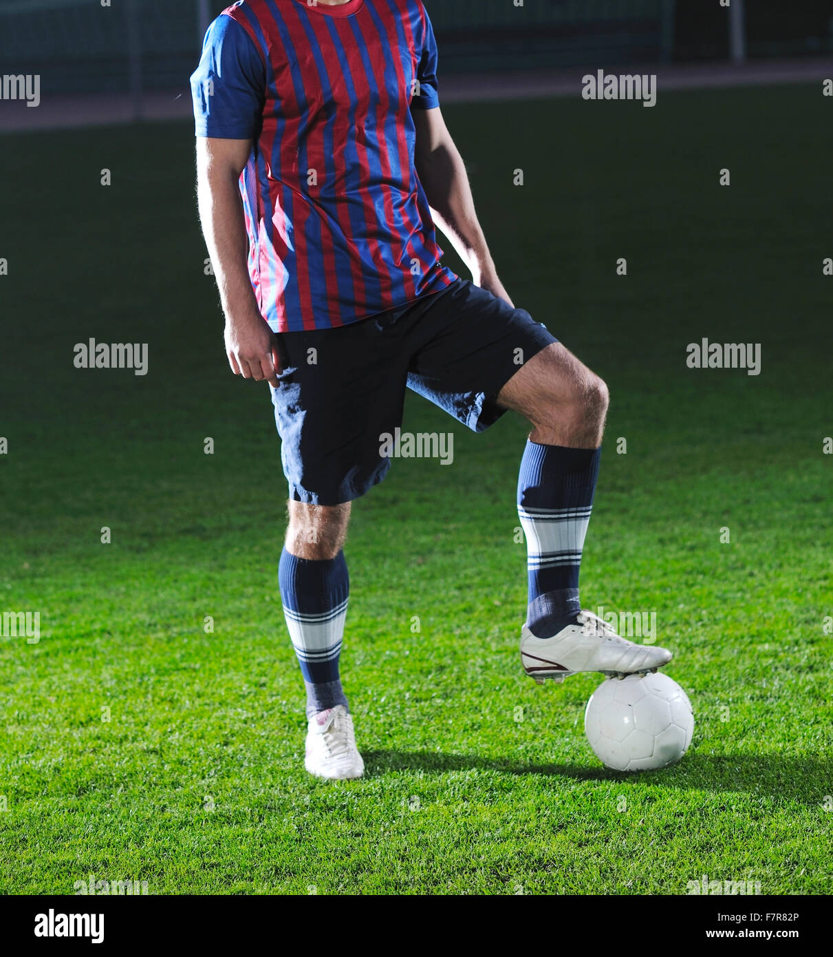portrait of young handsome soccer player man at football stadium and ...