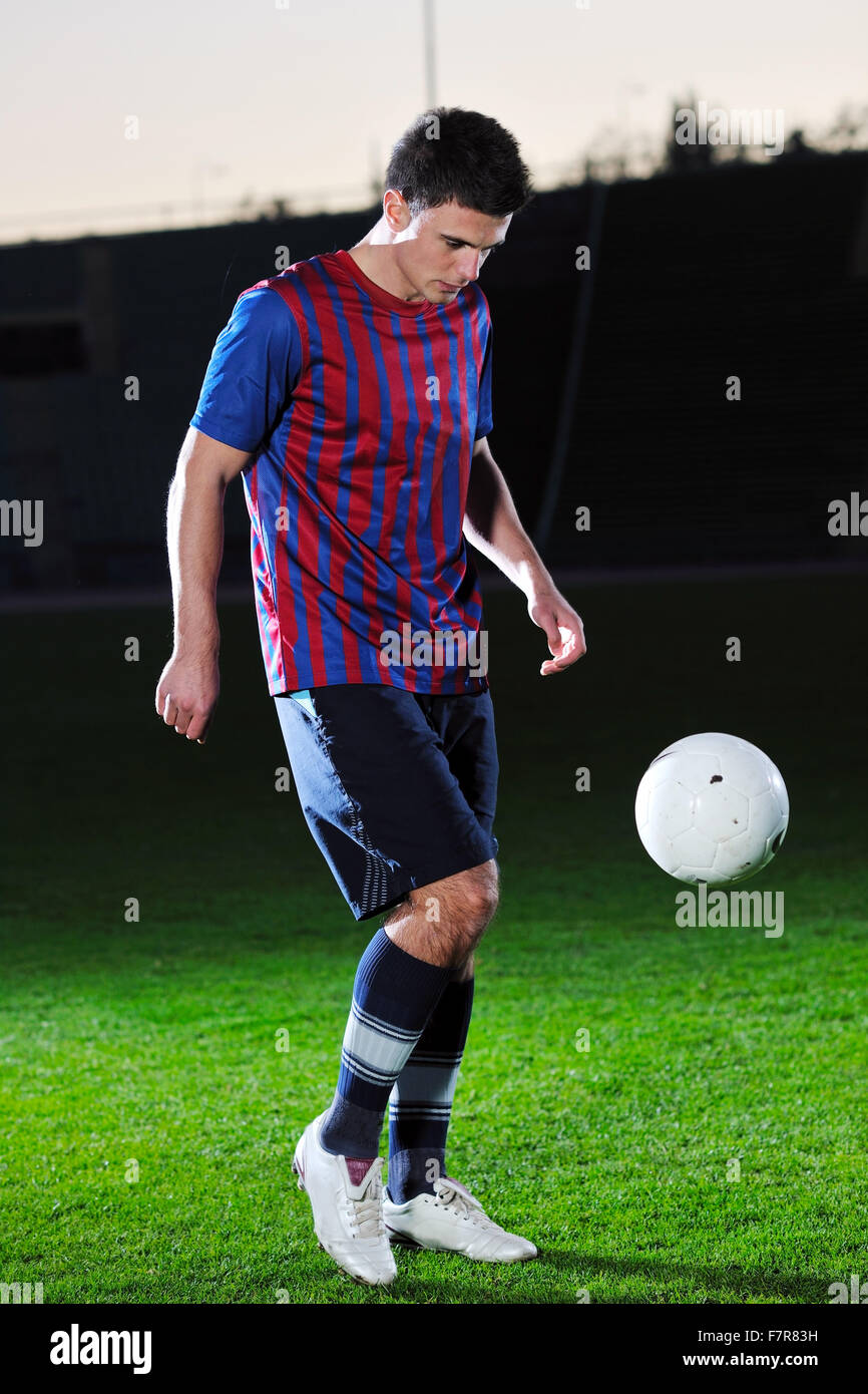 soccer player doing kick with ball on football stadium field isolated ...