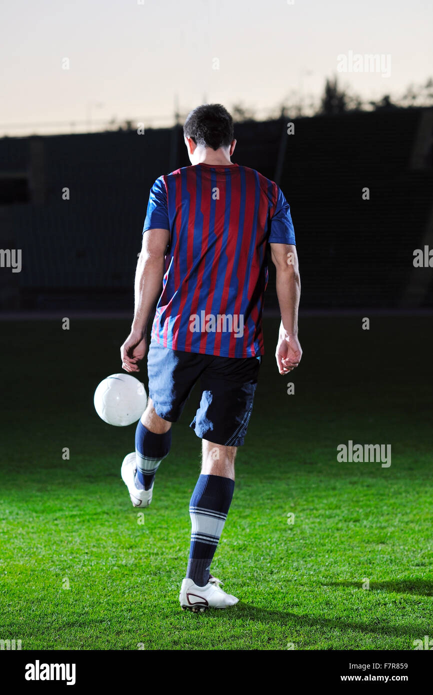 soccer player doing kick with ball on football stadium field isolated ...