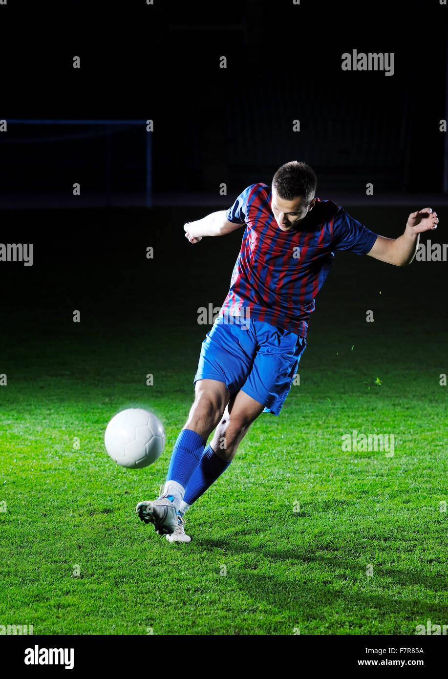 soccer player doing kick with ball on football stadium field isolated ...