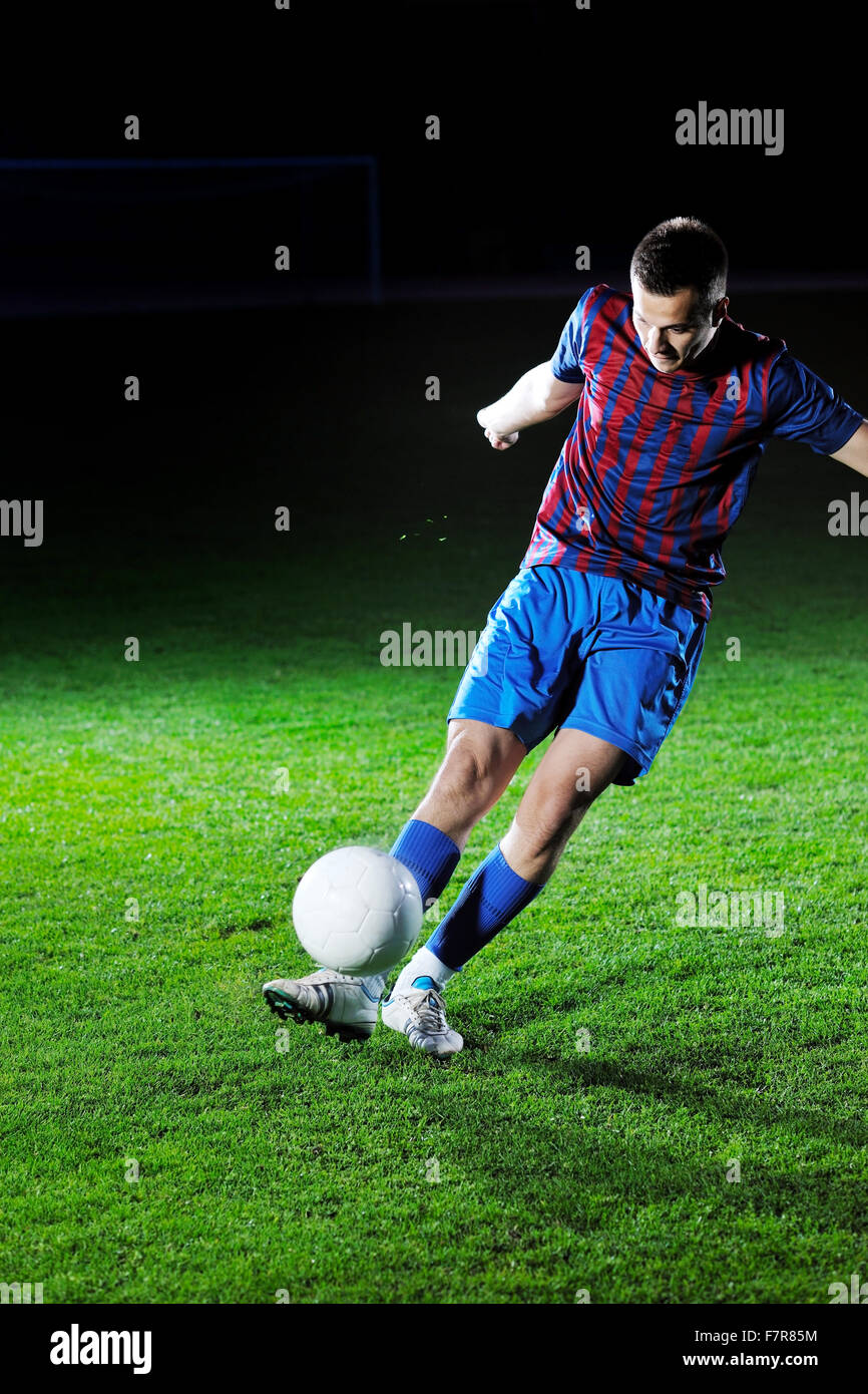soccer player doing kick with ball on football stadium field isolated ...