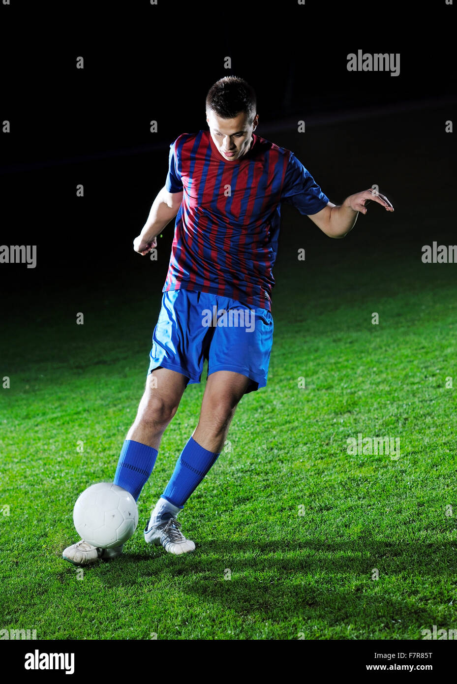 soccer player doing kick with ball on football stadium field isolated ...