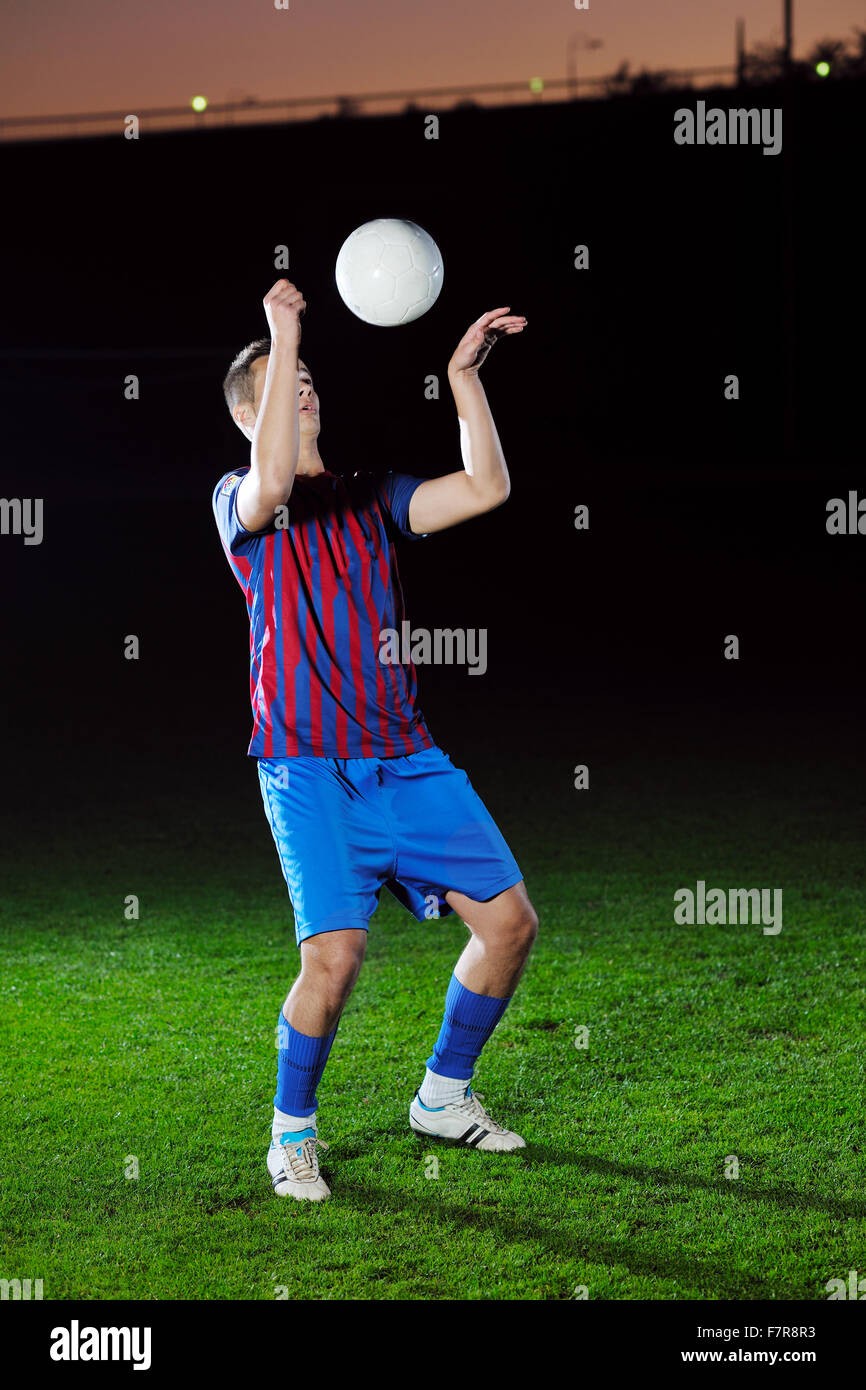 soccer player doing kick with ball on football stadium field isolated ...