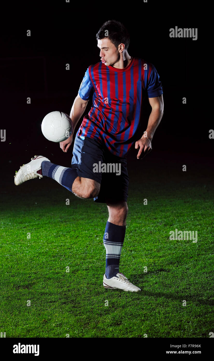 soccer player doing kick with ball on football stadium field isolated ...